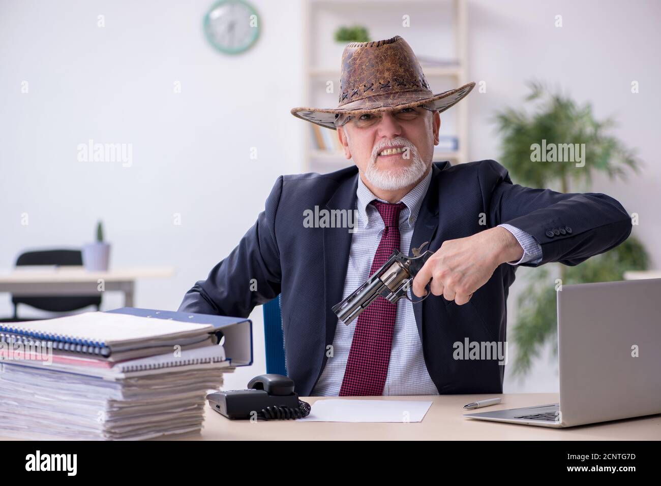 Funny old boss in cowboy hat in office Stock Photo - Alamy