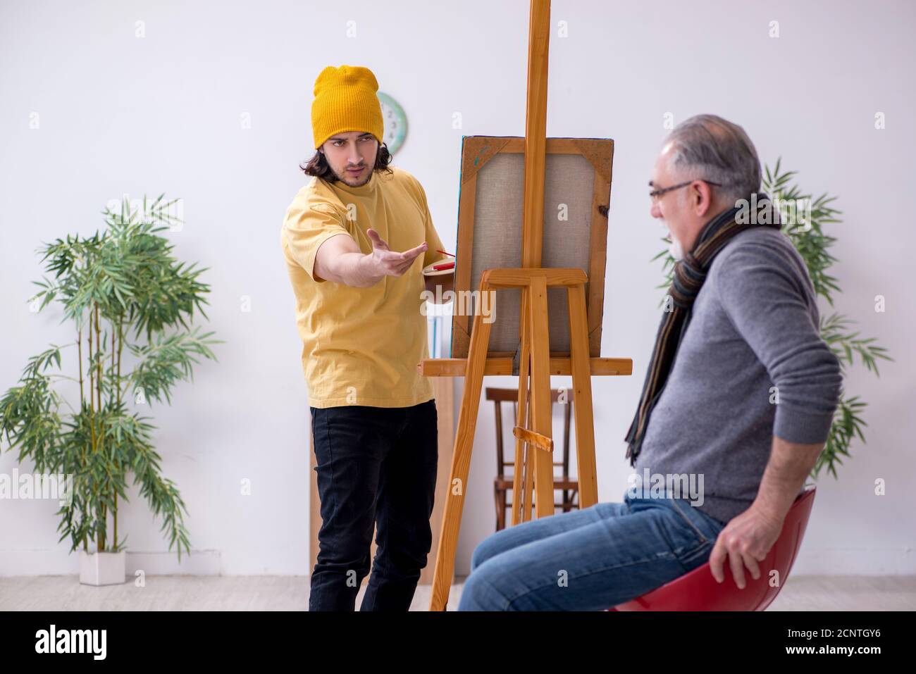 Young portraitist and old model Stock Photo - Alamy