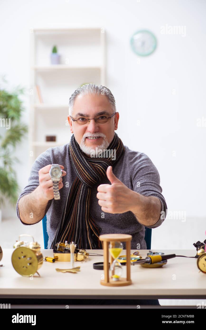 Old watchmaker working in the workshop Stock Photo - Alamy