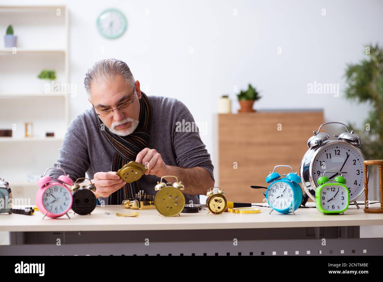 Old watchmaker working in the workshop Stock Photo - Alamy