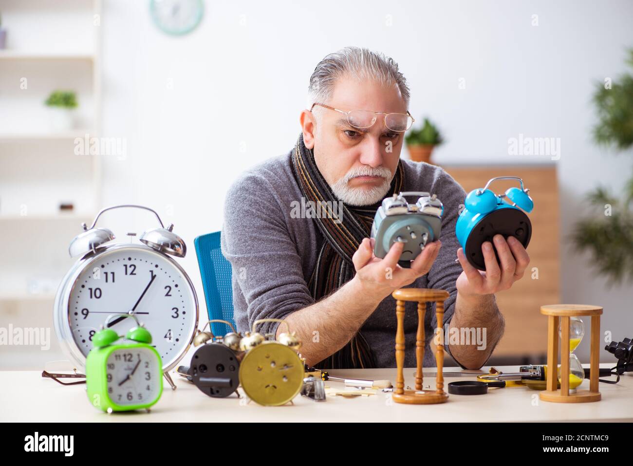 Old watchmaker working in the workshop Stock Photo - Alamy