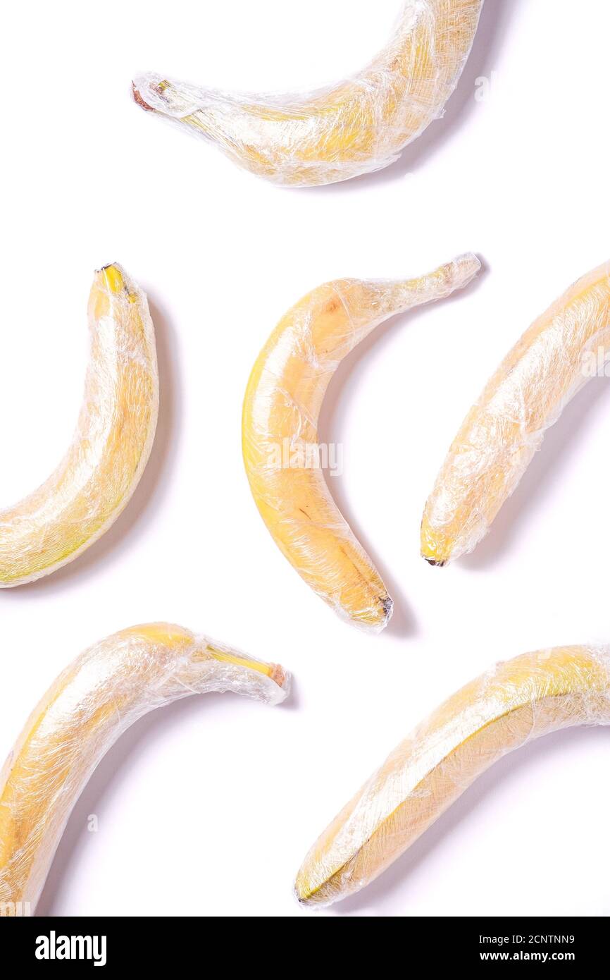 Banana fruits wrapped in stretch wrap plastic isolated background ...