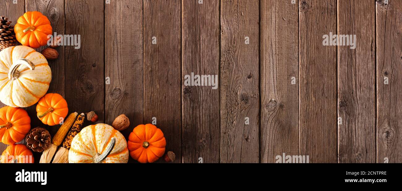 Autumn corner border banner of pumpkins and fall decor on a rustic wood ...