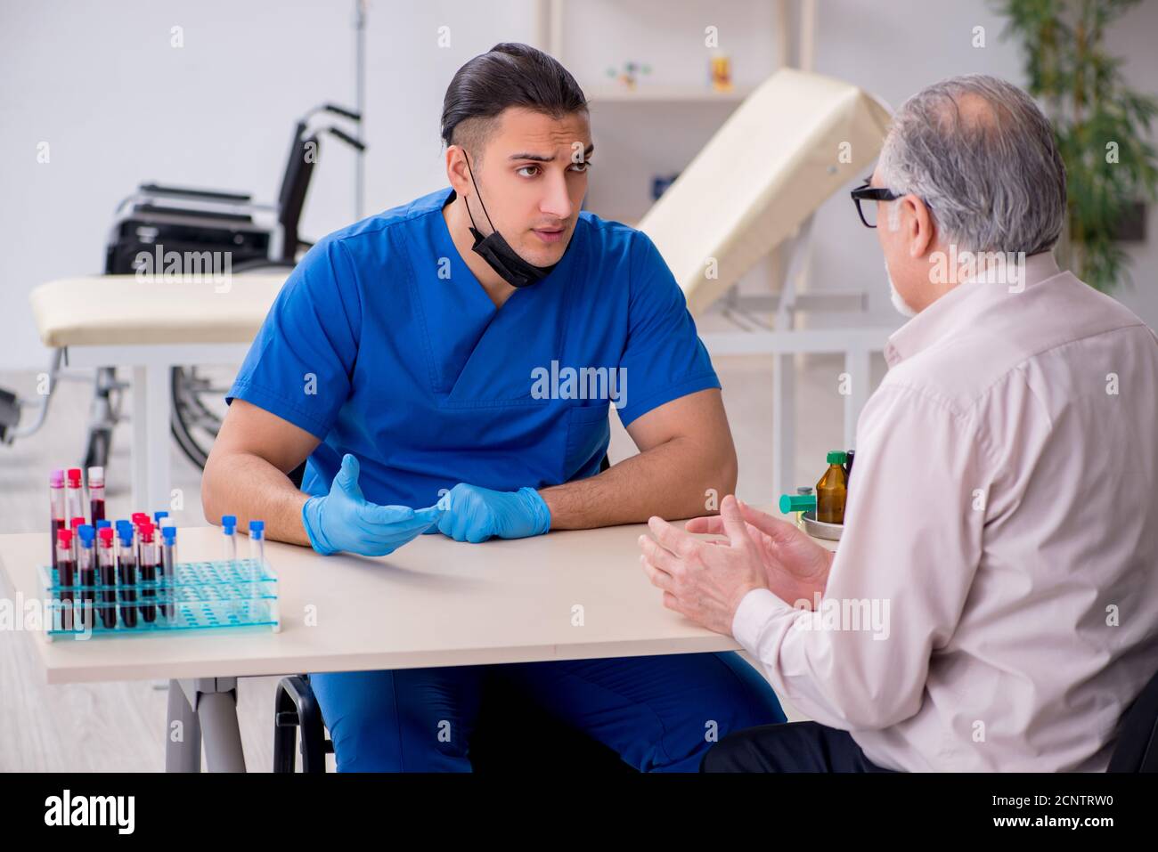 Old patient visiting young doctor Stock Photo - Alamy