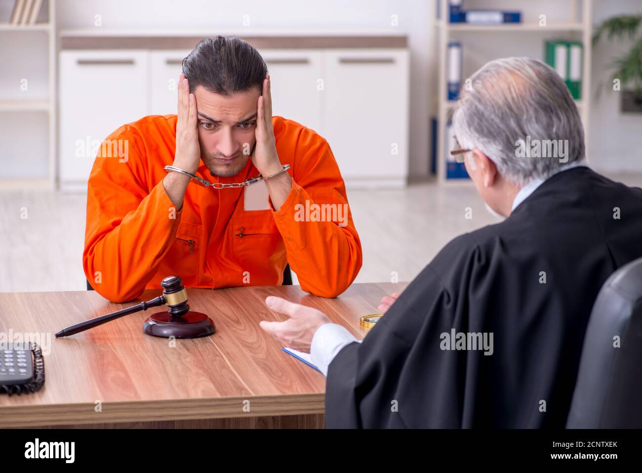 Old judge meeting with young captive in courthouse Stock Photo - Alamy