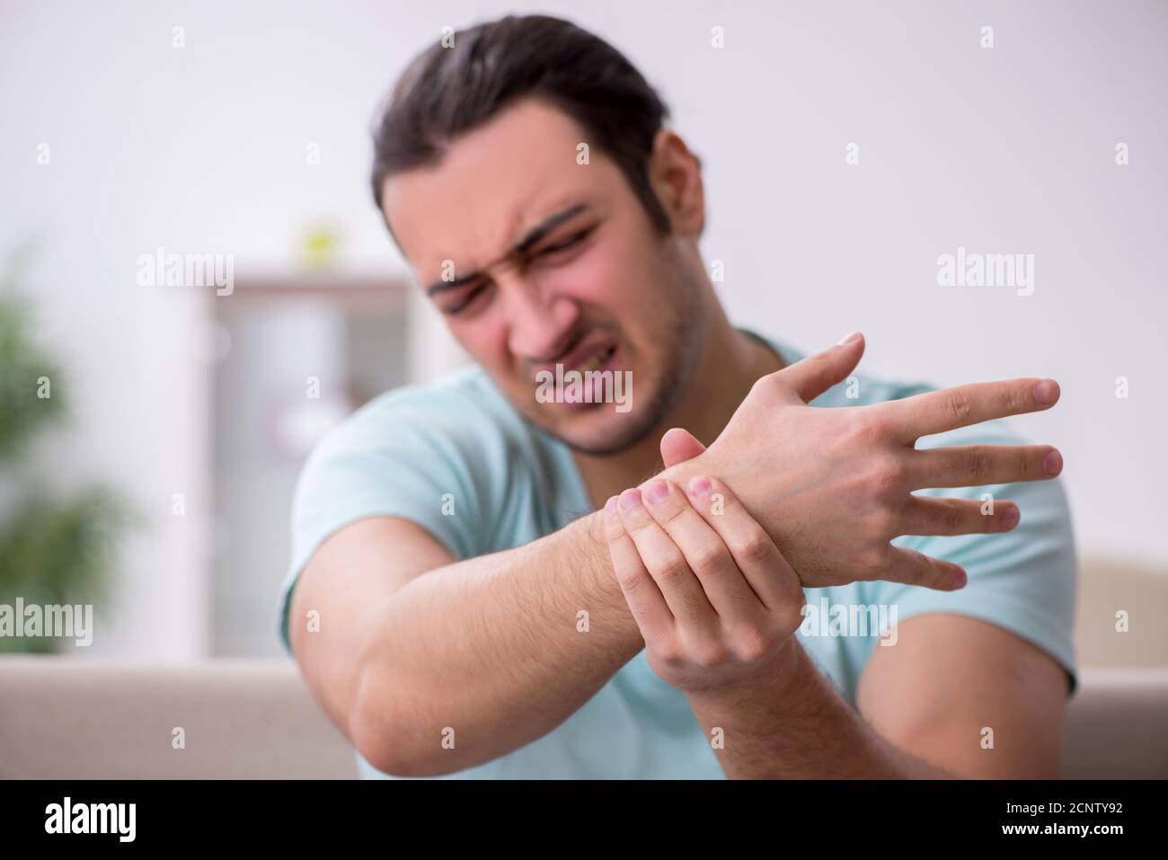 Injured young man suffering at the home Stock Photo - Alamy