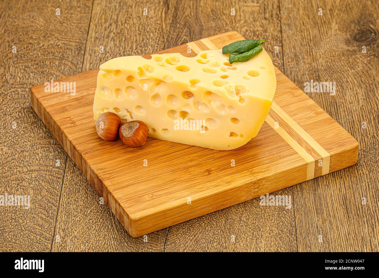 Maasdam cheese - dairy yellow triangle with holes Stock Photo - Alamy