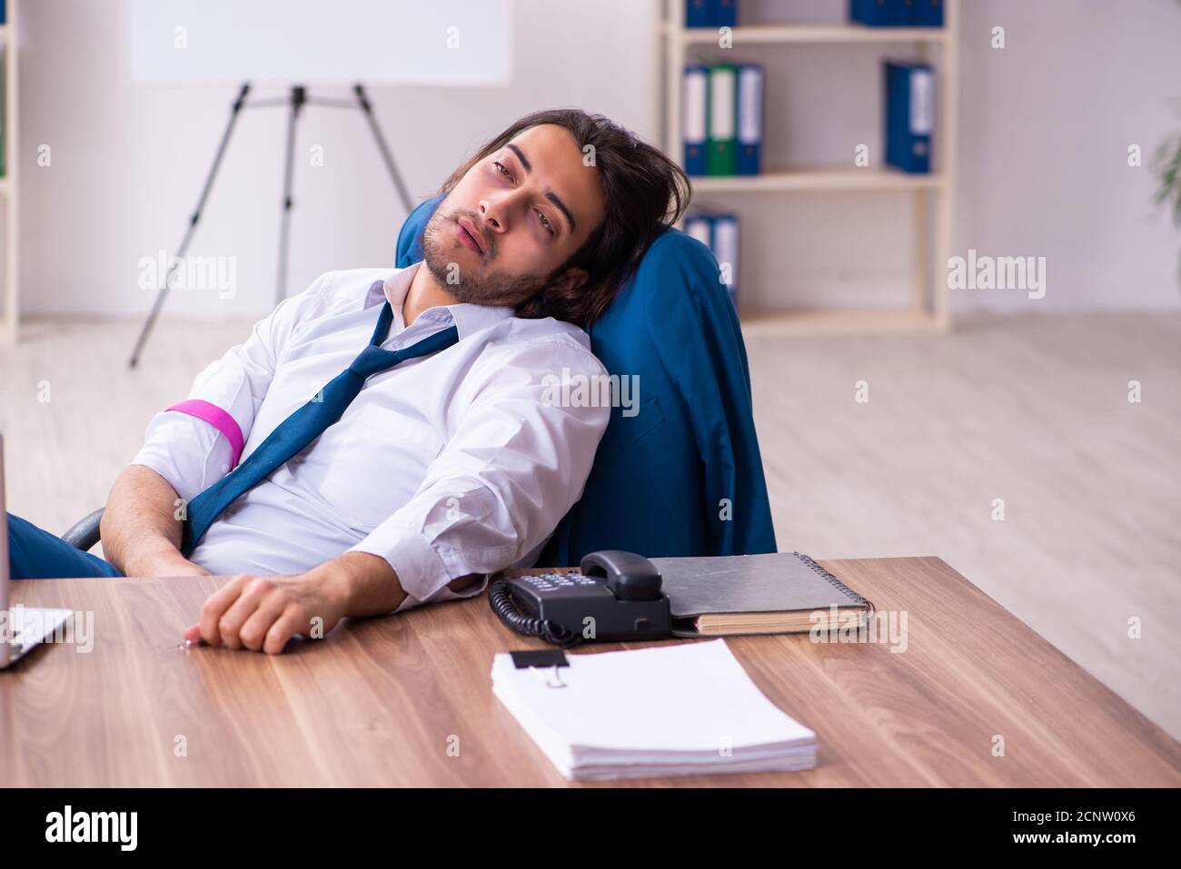 Drug addicted employee working in the office Stock Photo - Alamy