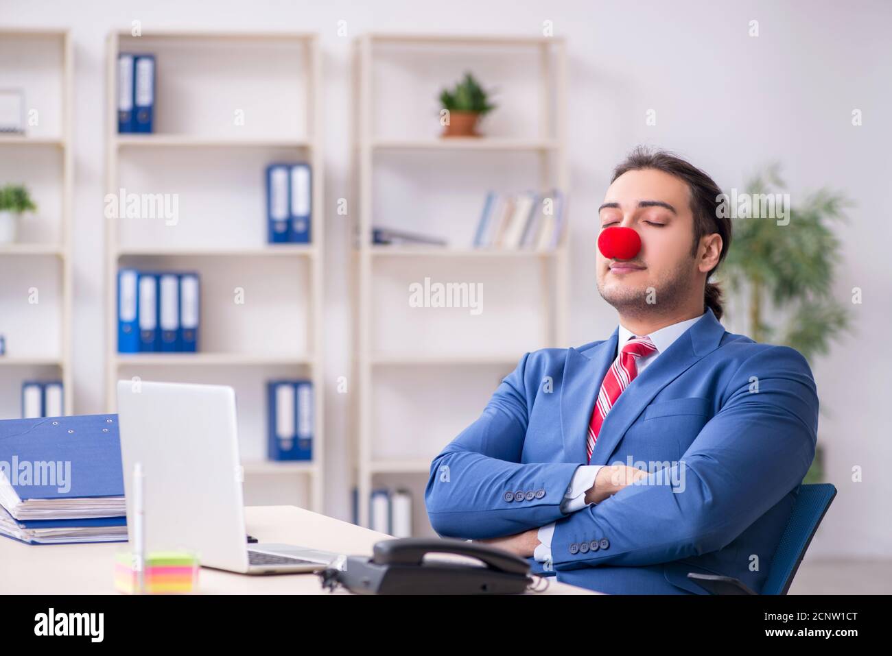 Funny employee clown working in the office room Stock Photo - Alamy