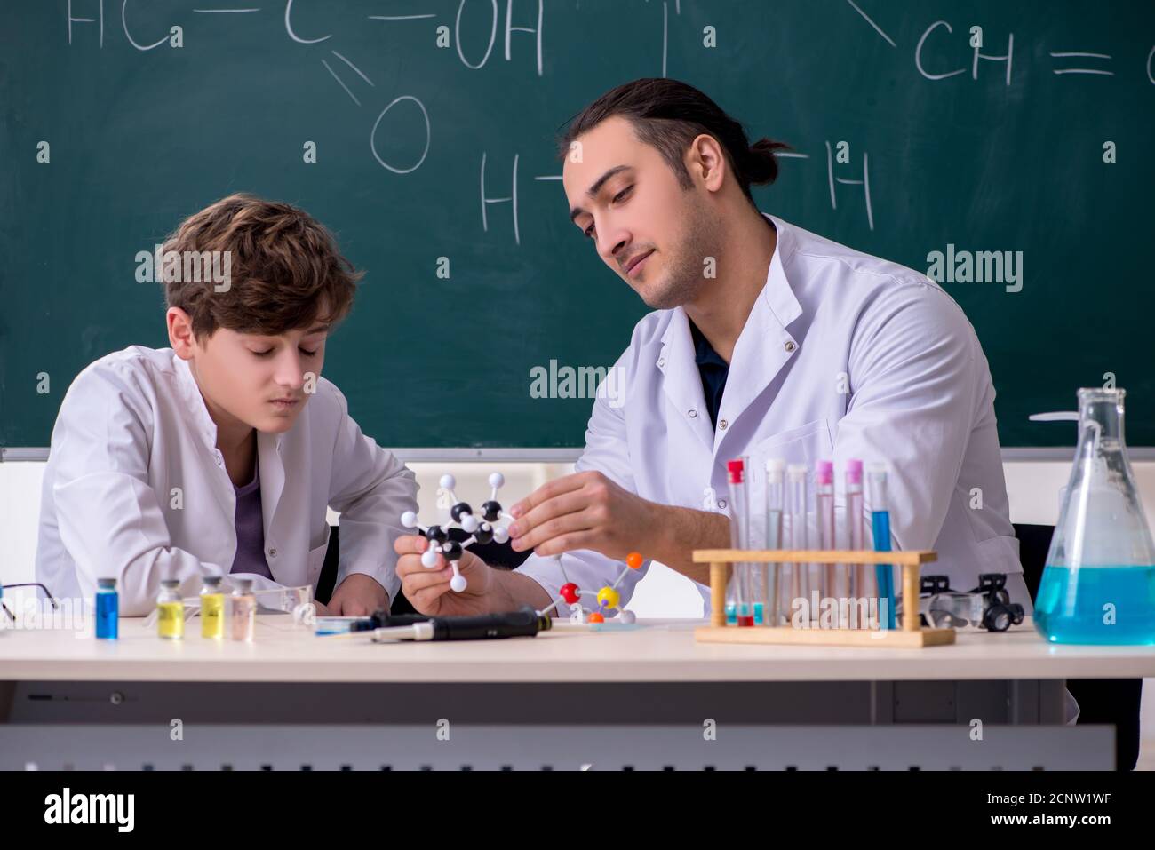 Young chemistry teacher and schoolboy in classroom Stock Photo - Alamy