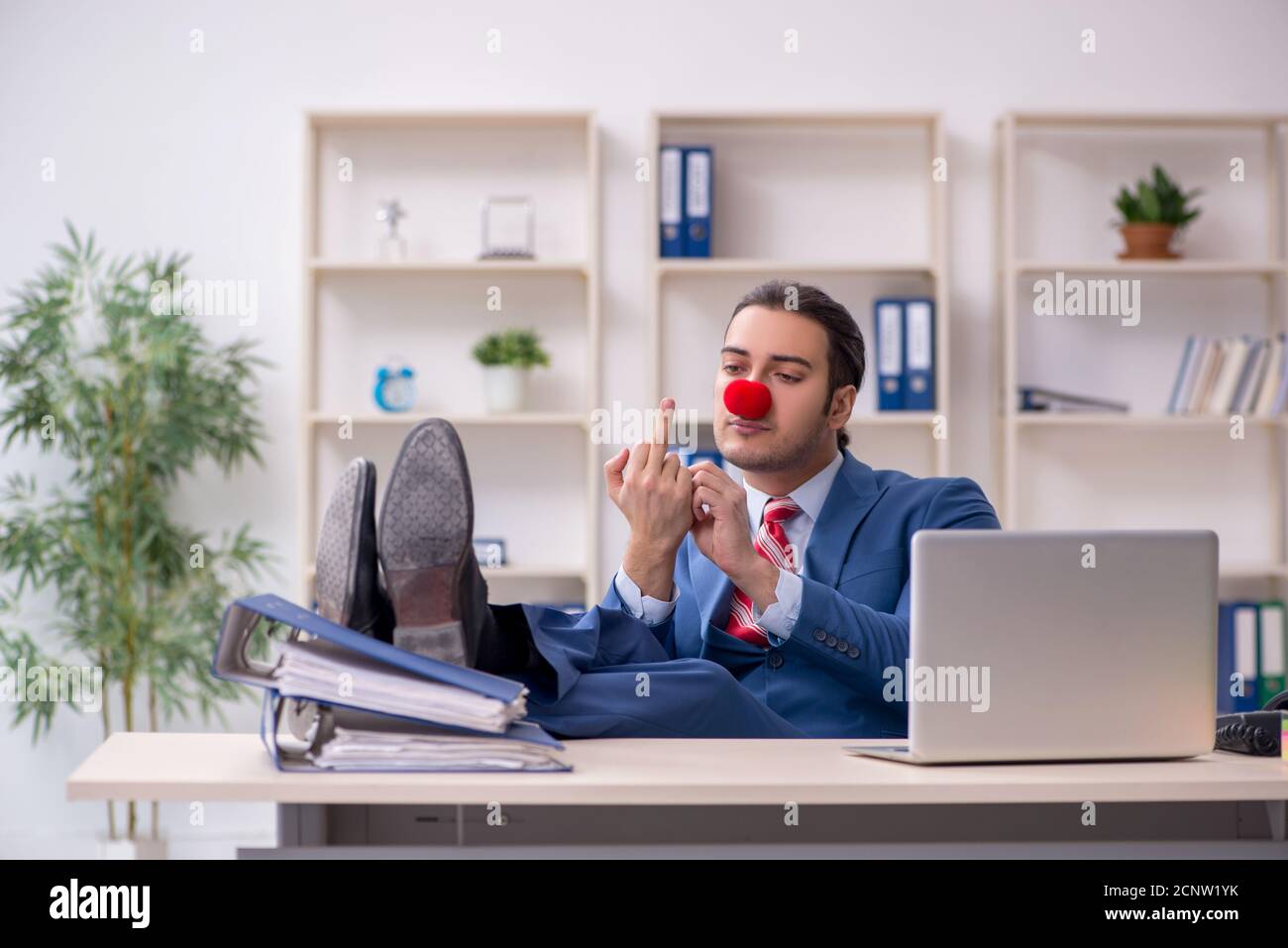 Funny employee clown working in the office room Stock Photo - Alamy
