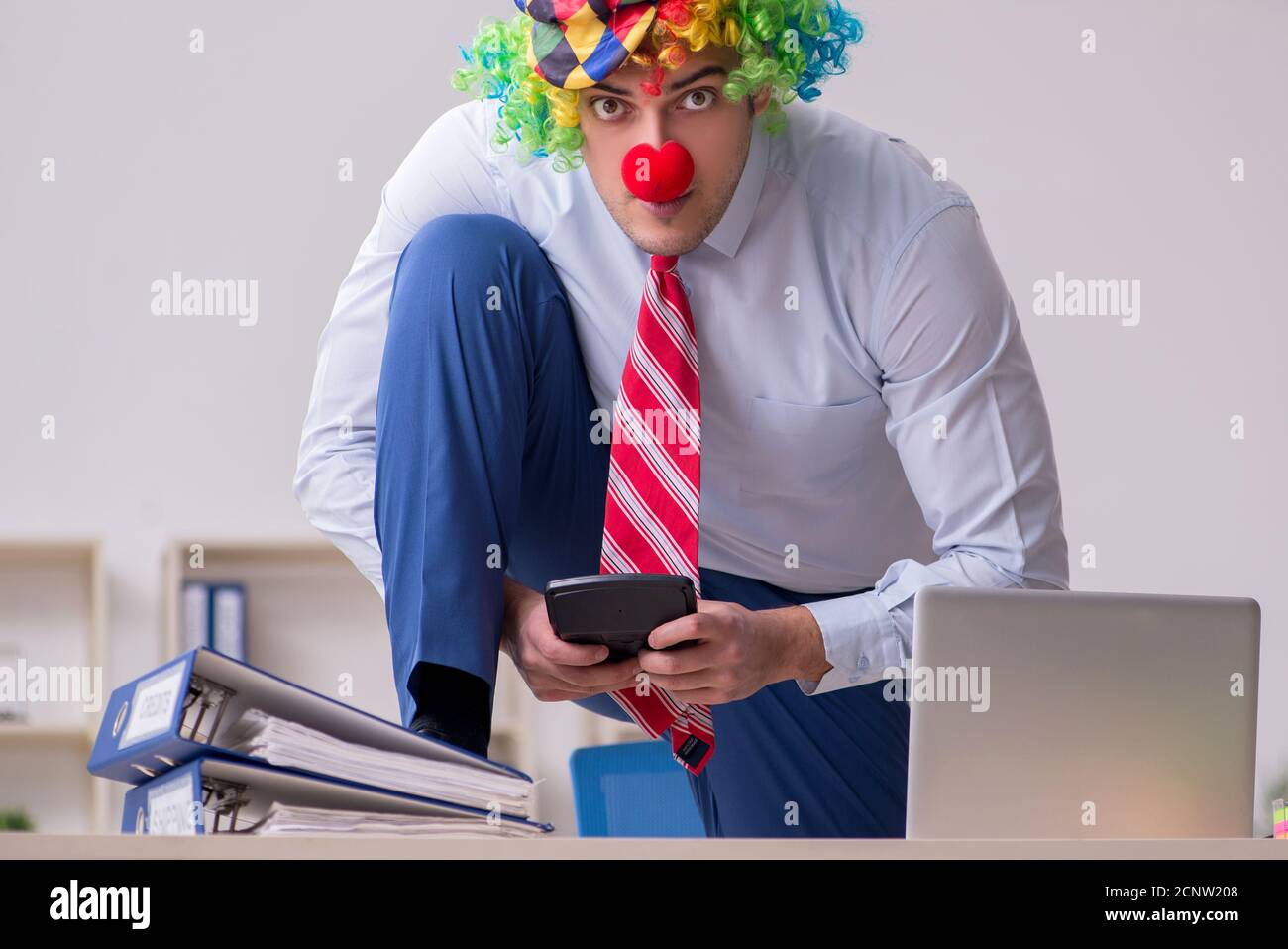 Funny employee clown working in the office room Stock Photo - Alamy