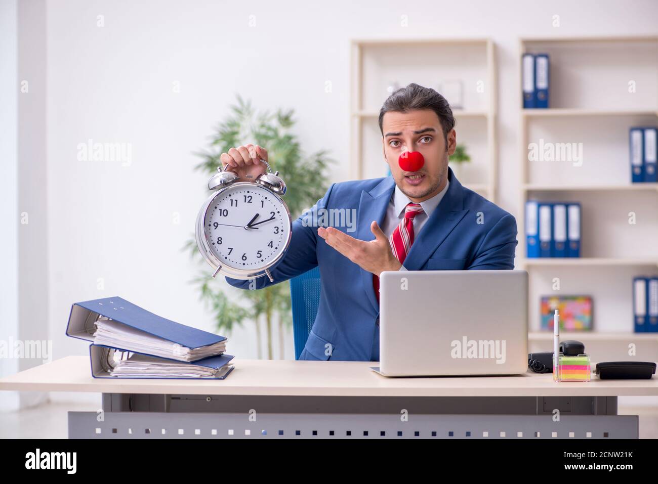 Funny employee clown working in the office room Stock Photo - Alamy