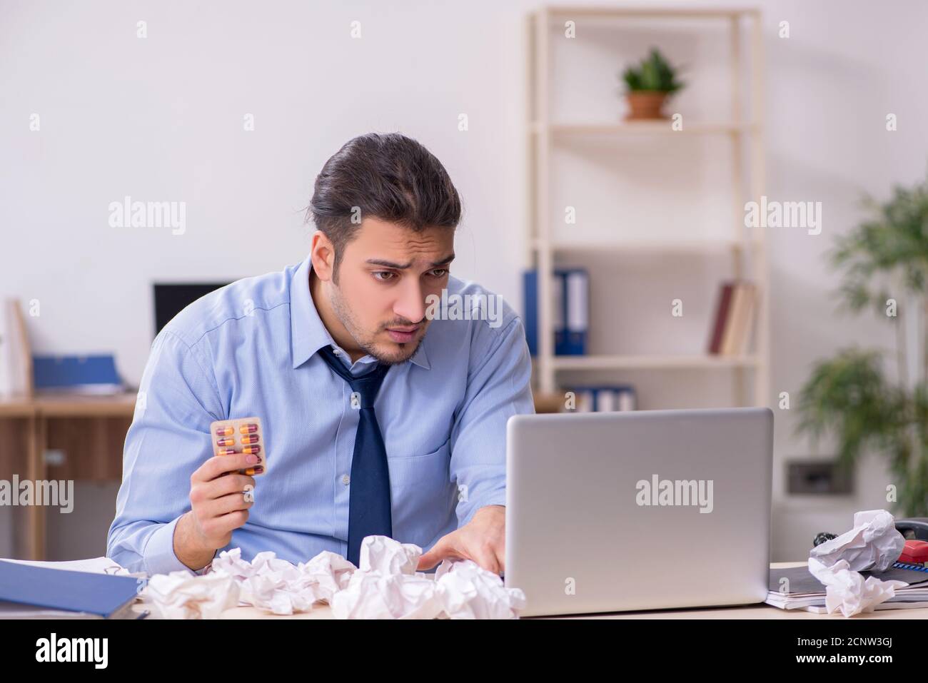 Sick male employee suffering at the workplace Stock Photo - Alamy