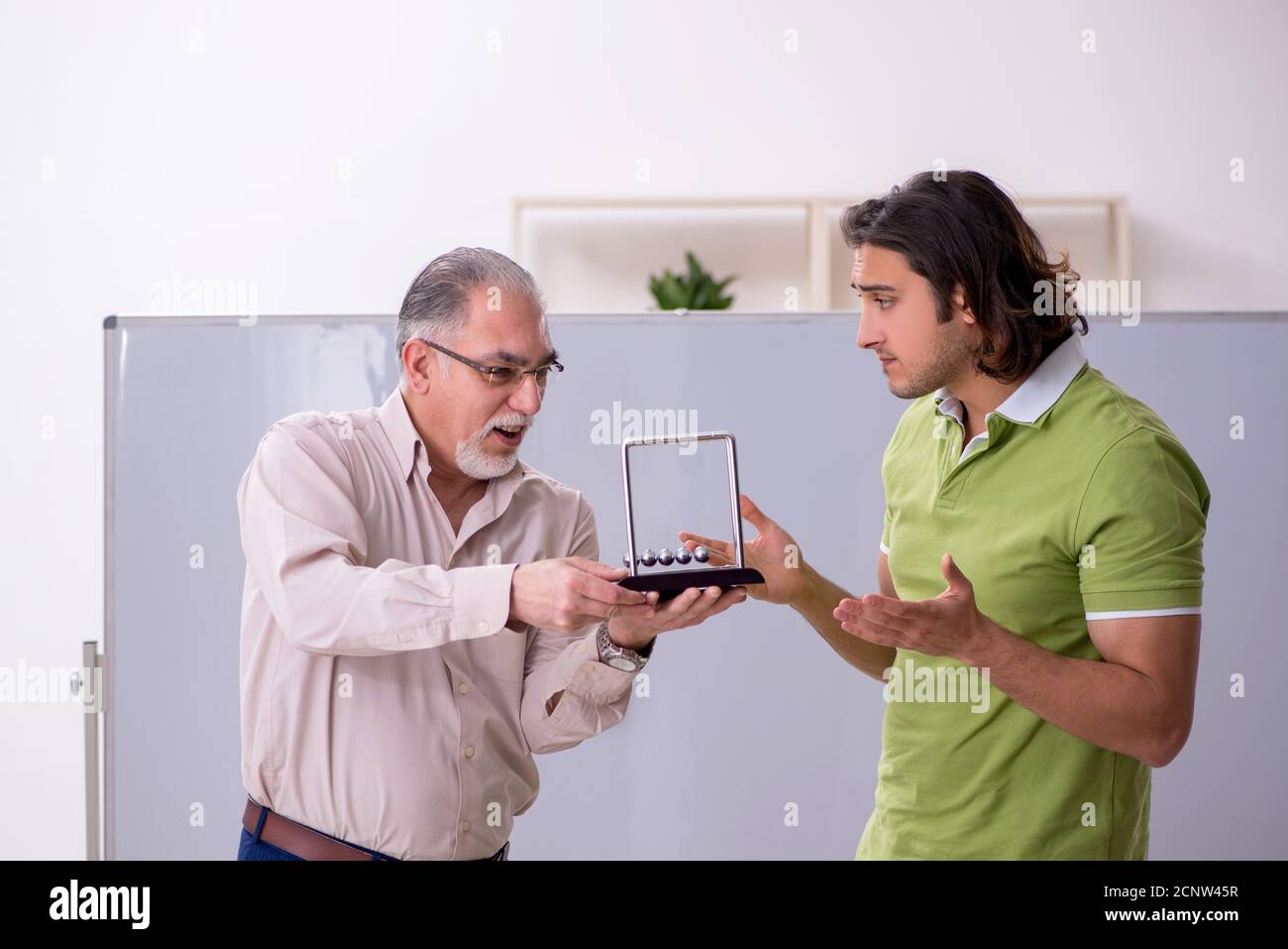 Old professor physicist and student in the classroom Stock Photo - Alamy