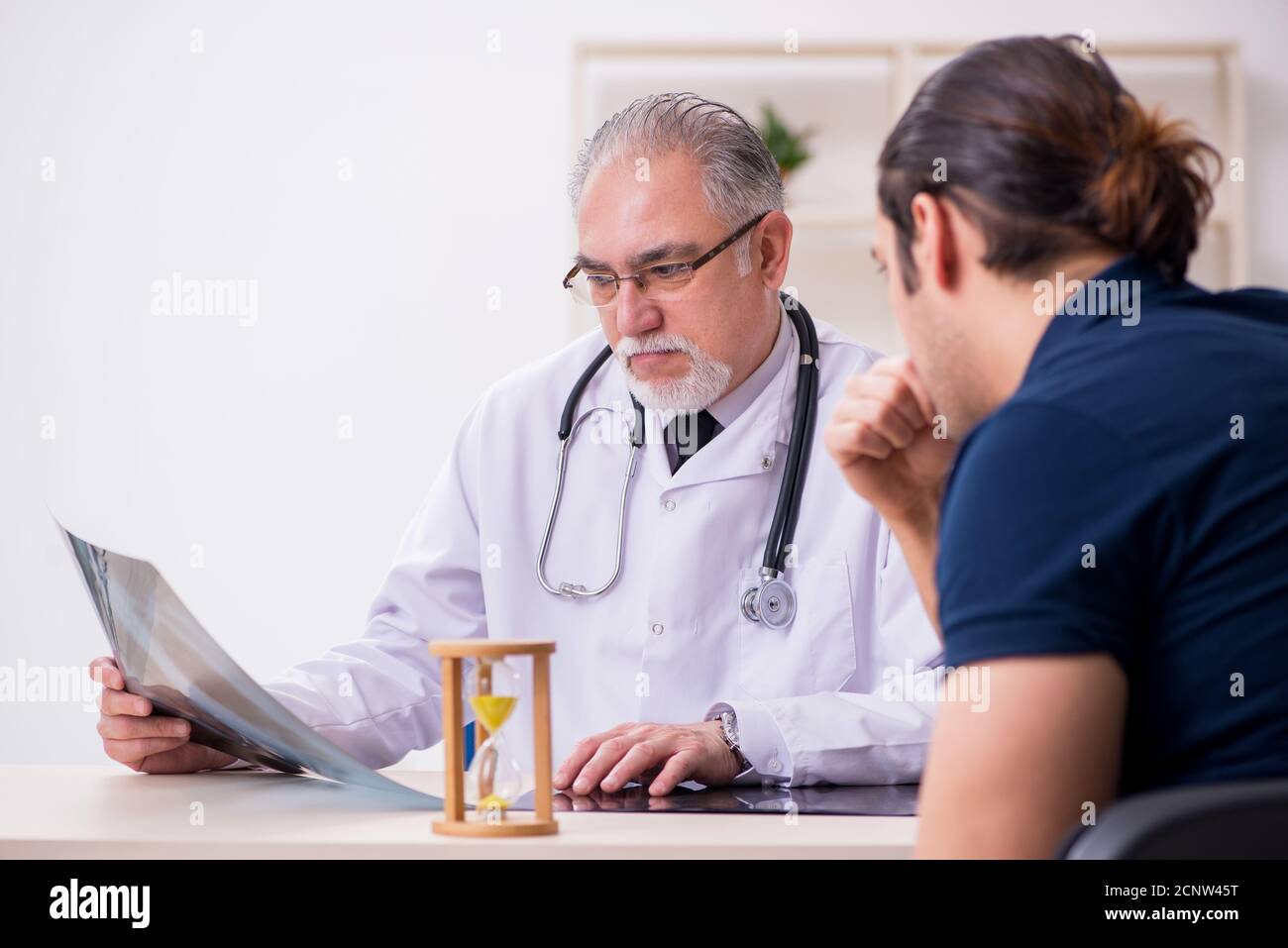 Male patient visiting doctor radiologist in time management concept ...
