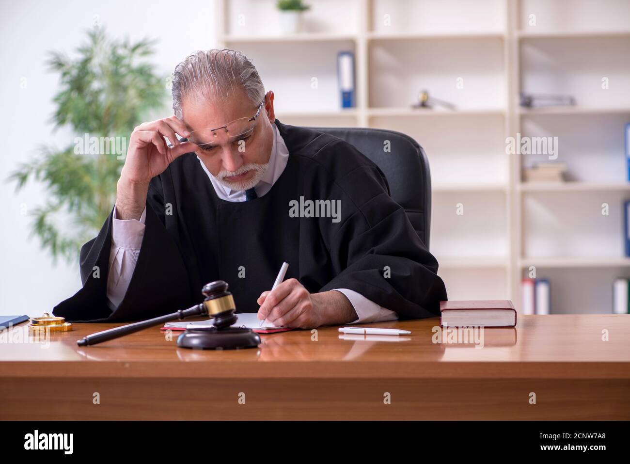 Old male judge working in the courthouse Stock Photo - Alamy
