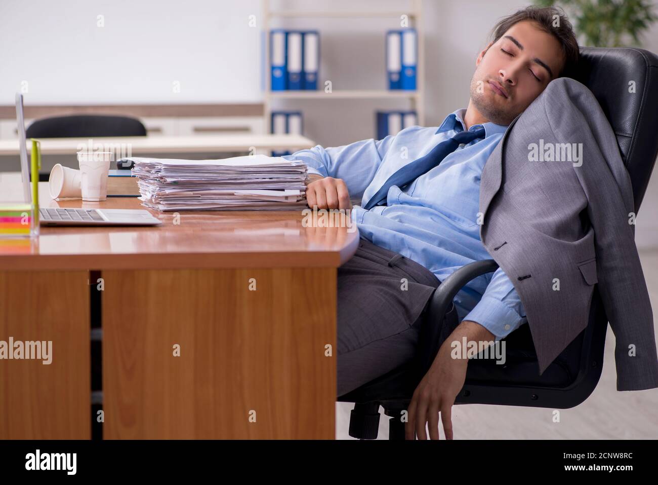 Young employee sleeping in the office Stock Photo - Alamy