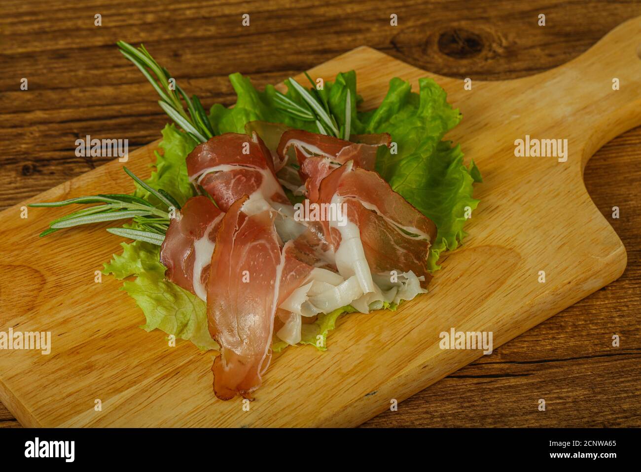 Sliced pork Jamon meat with rosemary Stock Photo - Alamy