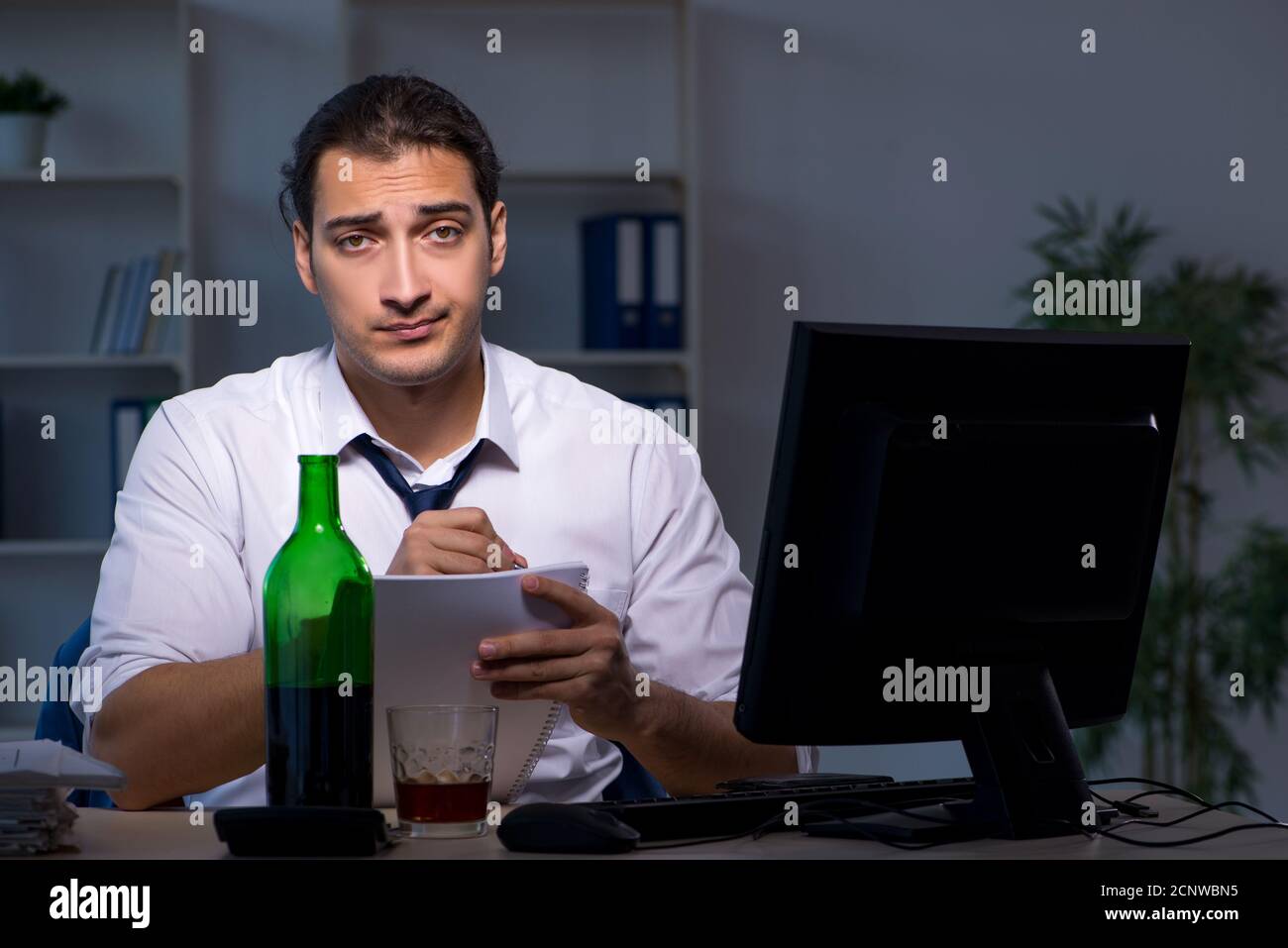 Alcohol addicted businessman working late Stock Photo - Alamy
