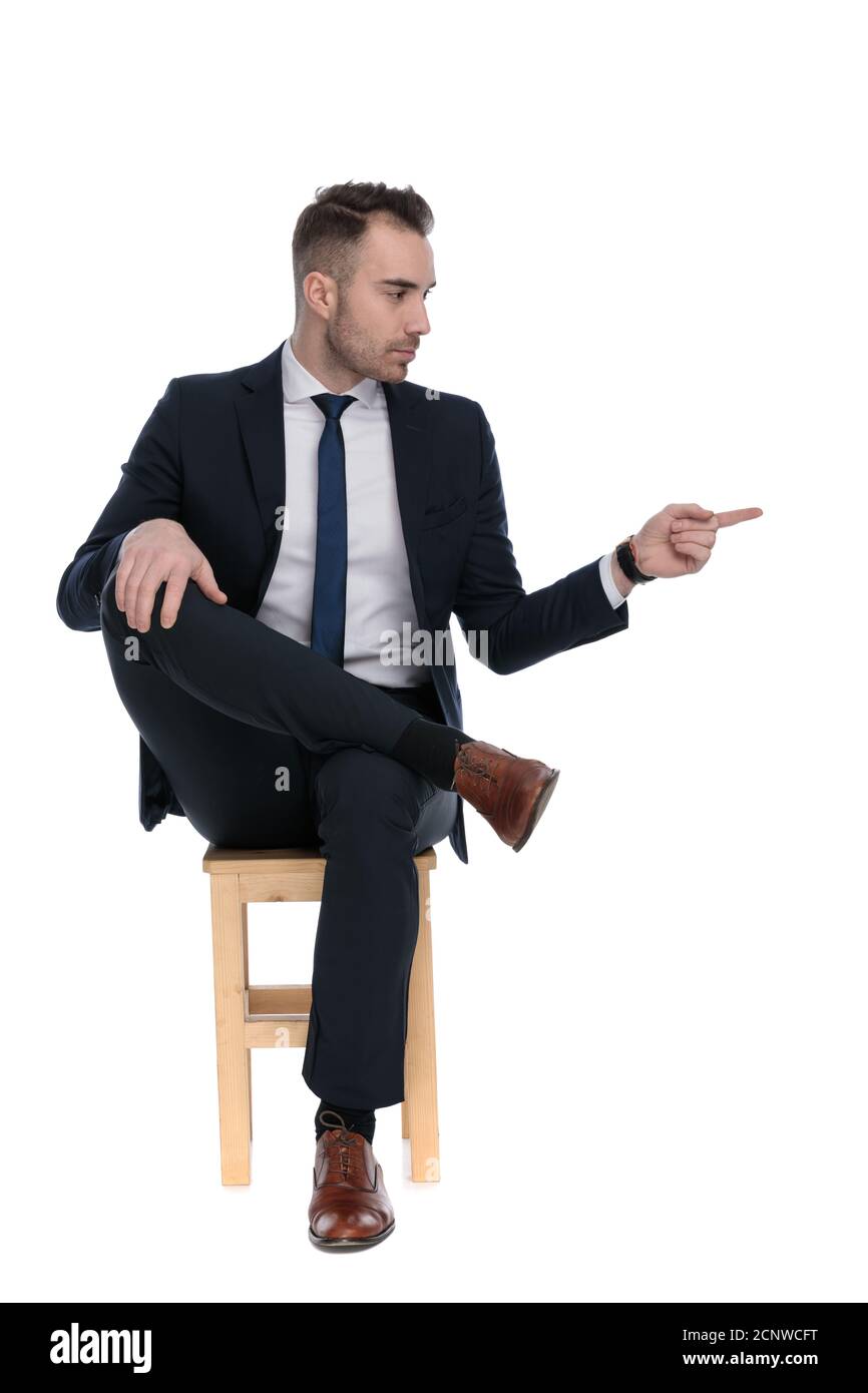 Serious businessman pointing and giving commands while sitting on a ...