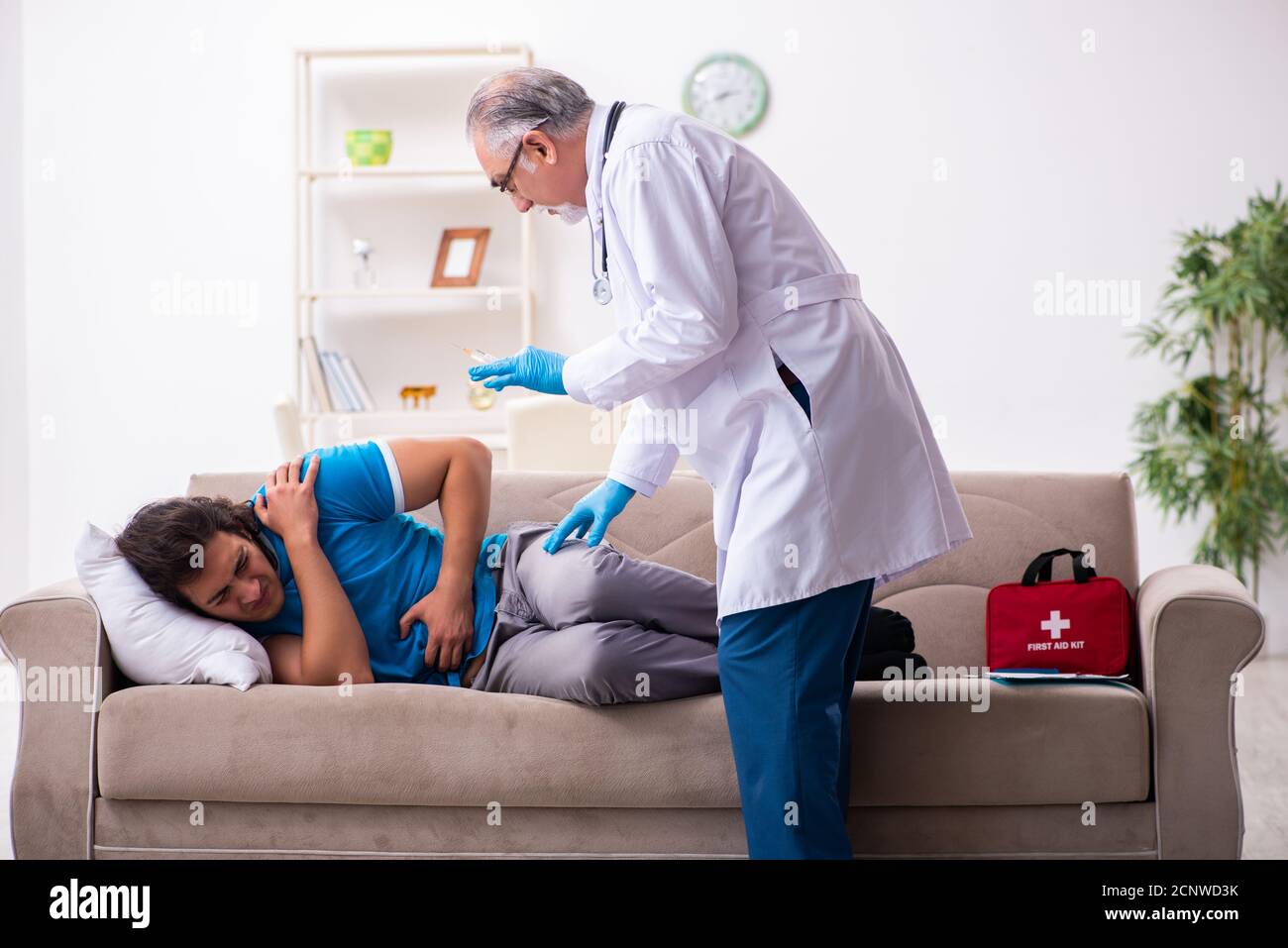 Two doctors visiting sick man at home Stock Photo - Alamy