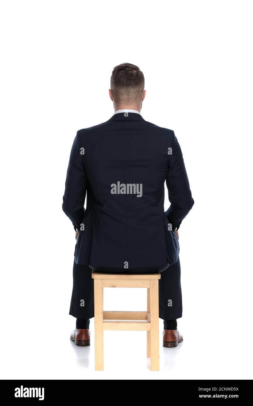 Back view of a businessman wearing suit and sitting on a chair on white ...
