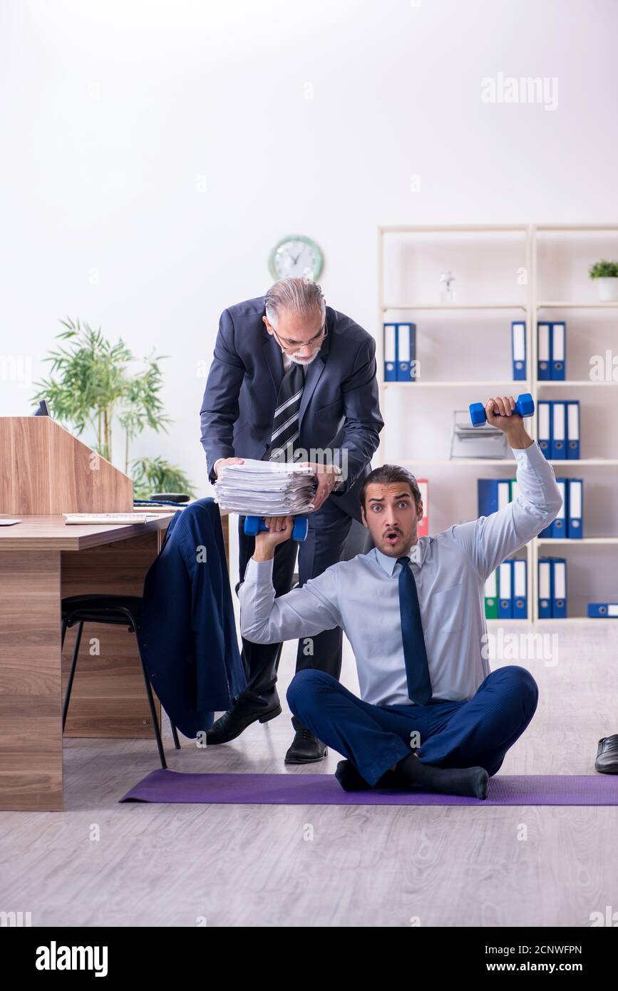 Two employees doing physical exercises at the workplace Stock Photo - Alamy