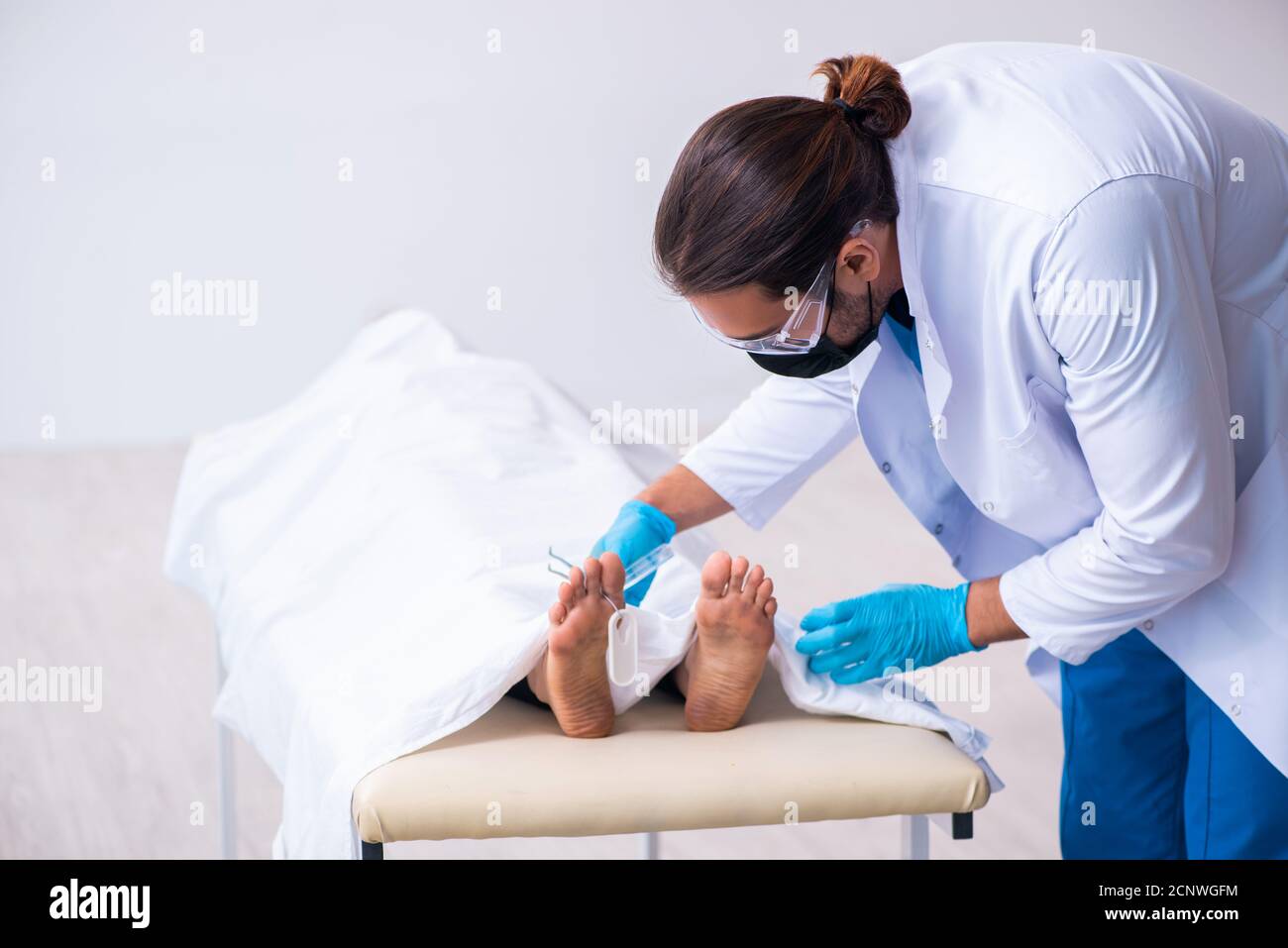 Police coroner examining dead body in morgue Stock Photo - Alamy