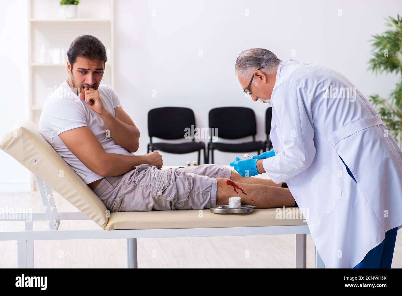 Leg injured man visiting doctor in first aid concept Stock Photo - Alamy