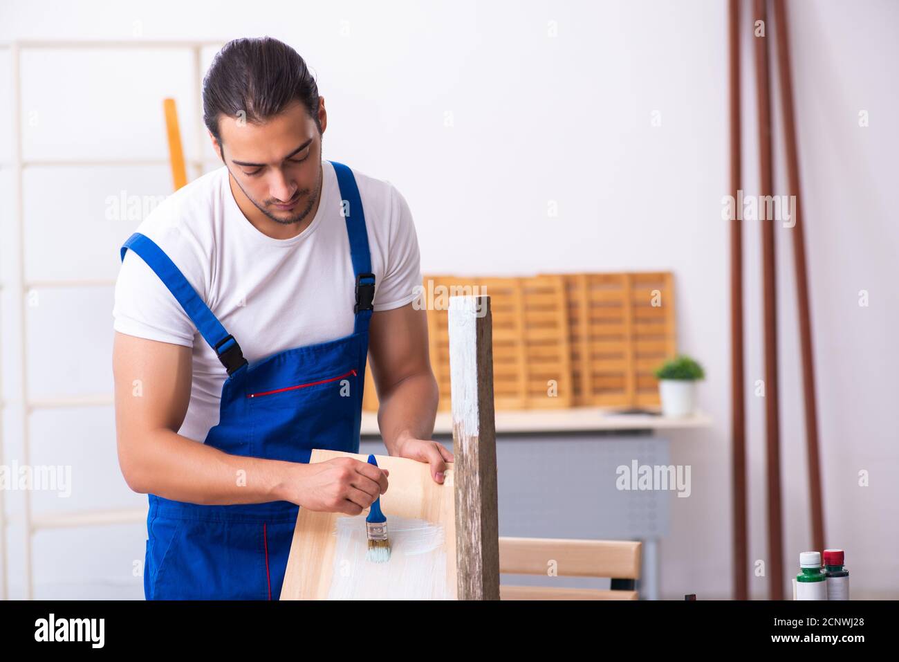Young male contractor working in the workshop Stock Photo - Alamy