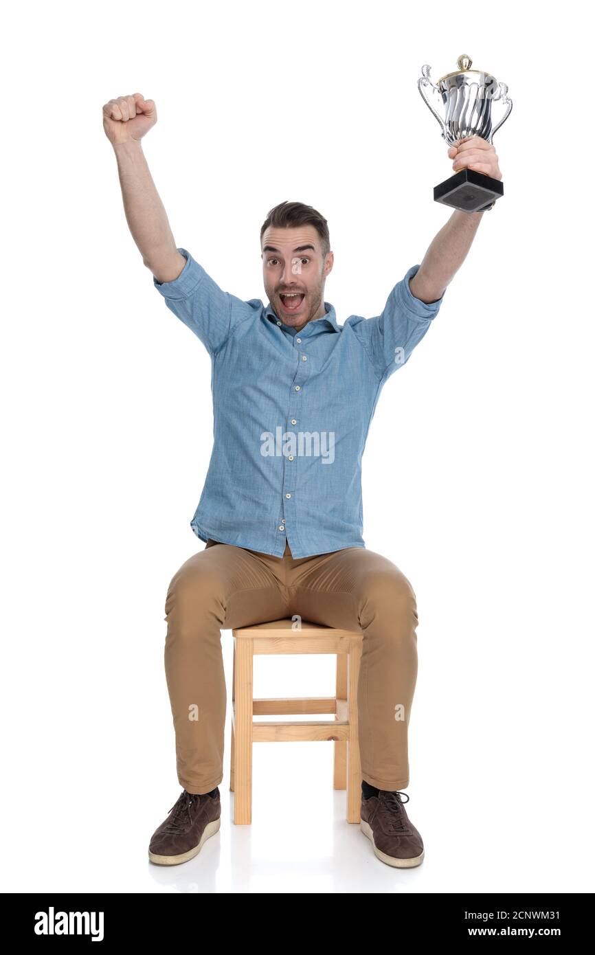 Happy smart casual man celebrating and holding trophy above head ...