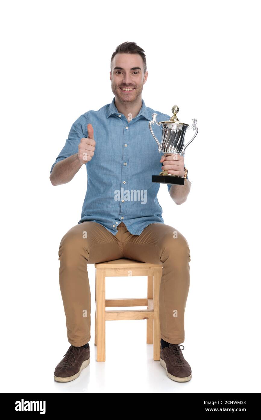 Happy smart casual man holding trophy, gesturing ok and smiling while ...