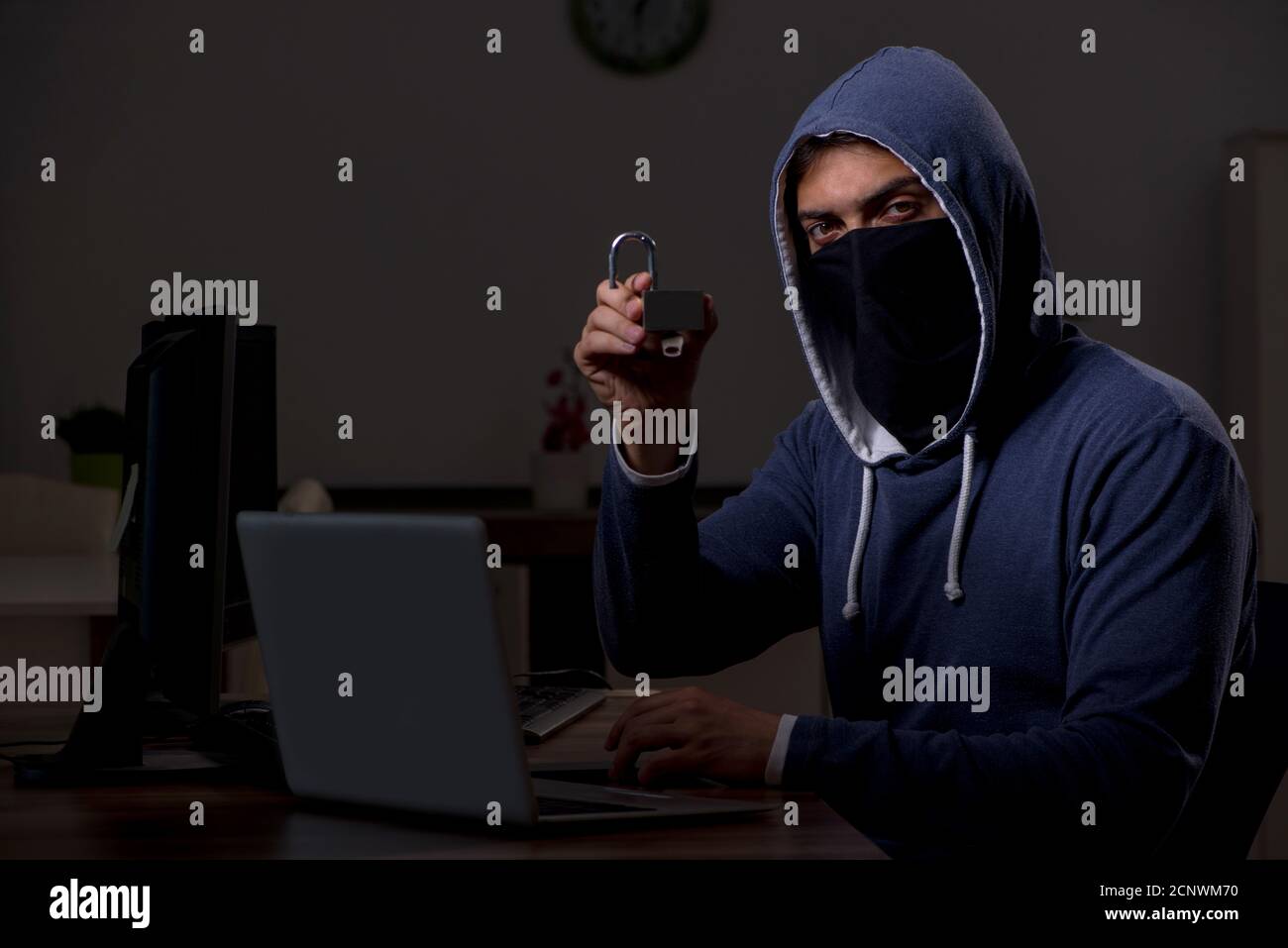 Male hacker hacking security firewall late in the office Stock Photo ...
