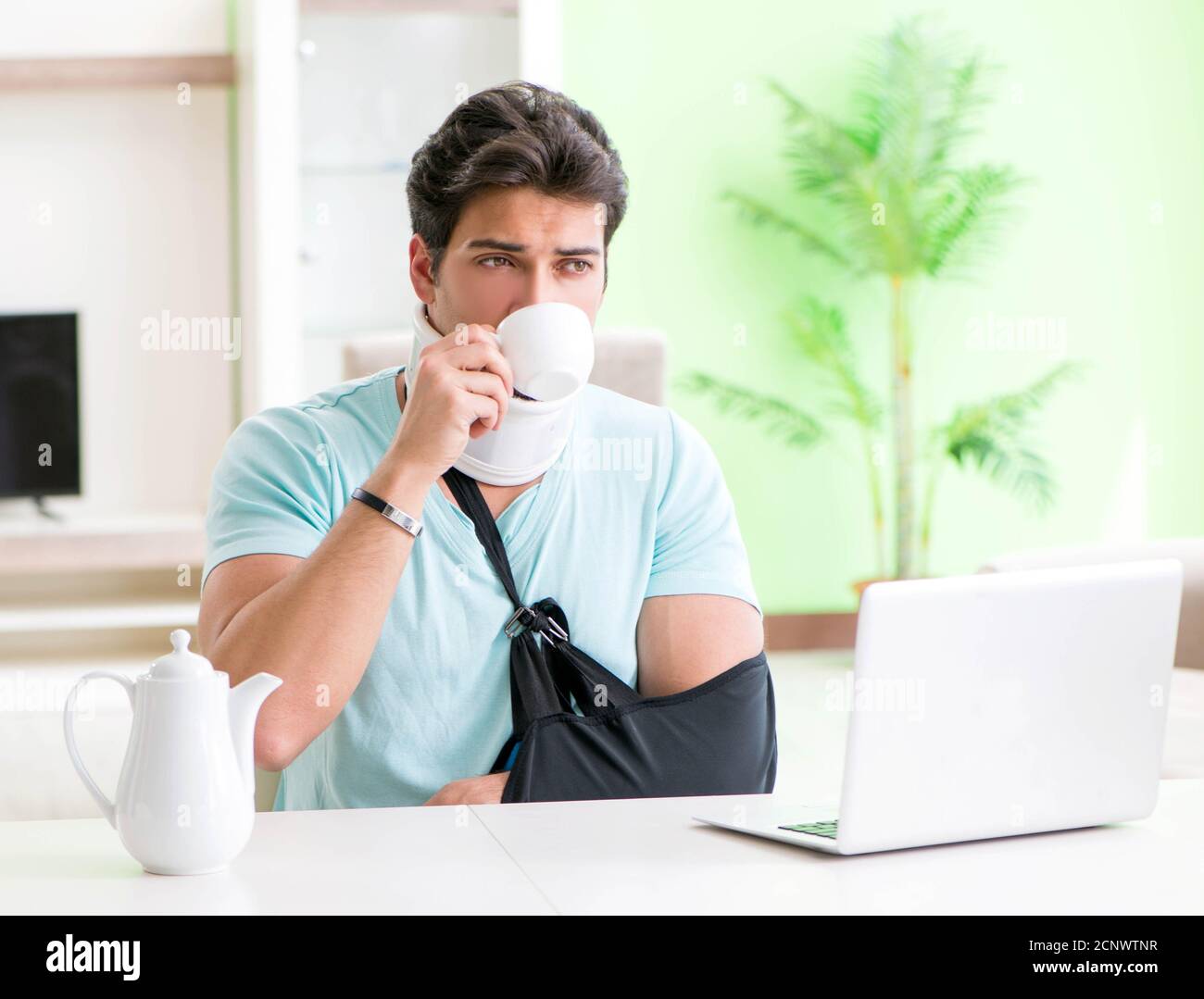 The young student man with neck and hand injury at home Stock Photo - Alamy