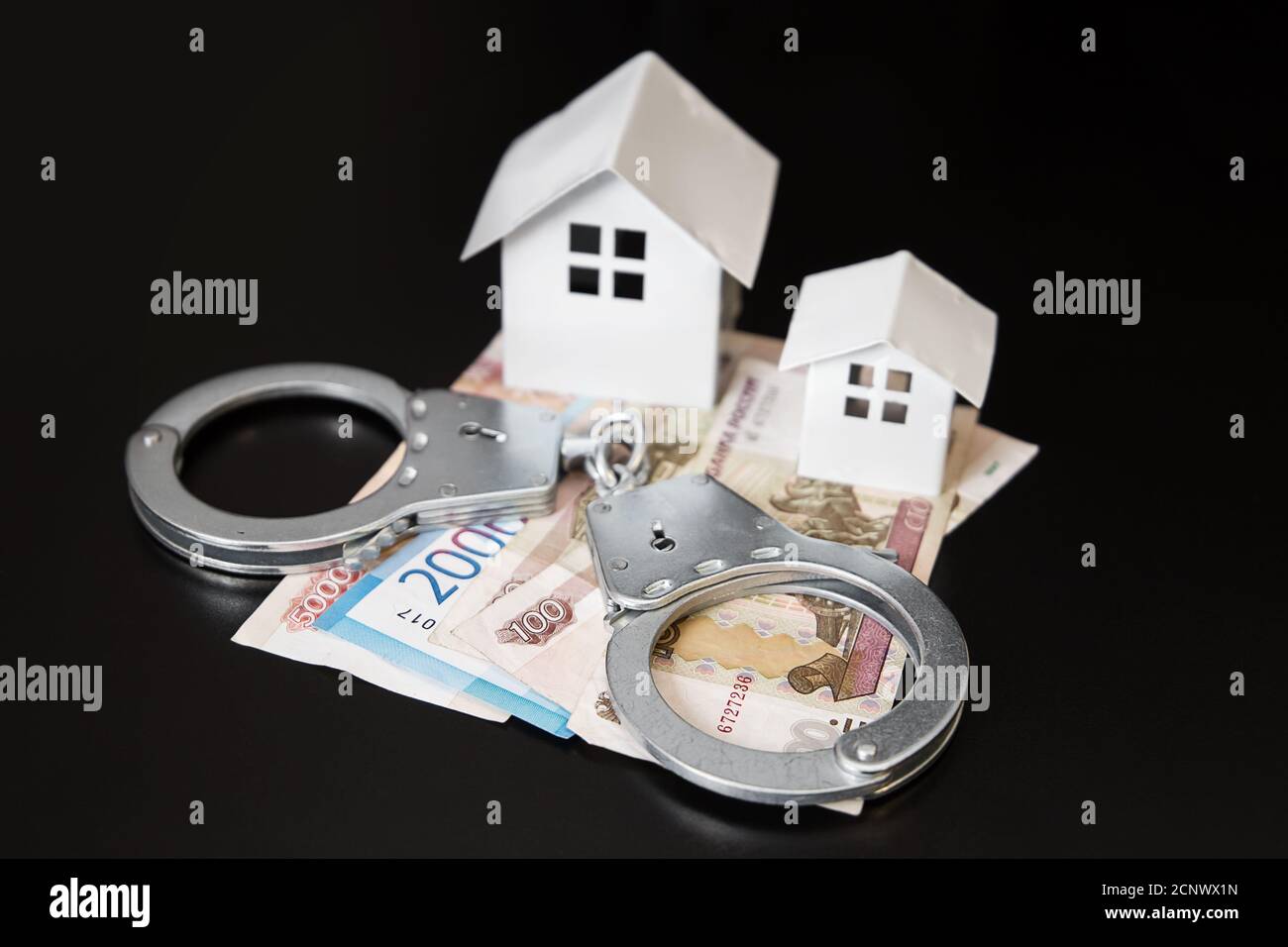 Money, handcuffs and houses on a dark background. Housing Fraud Stock ...