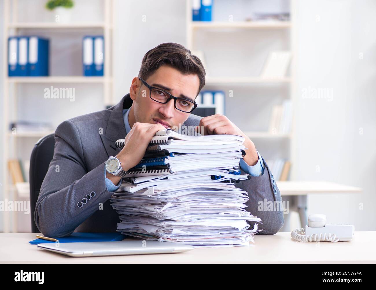The overloaded with work employee under paperwork burden Stock Photo ...