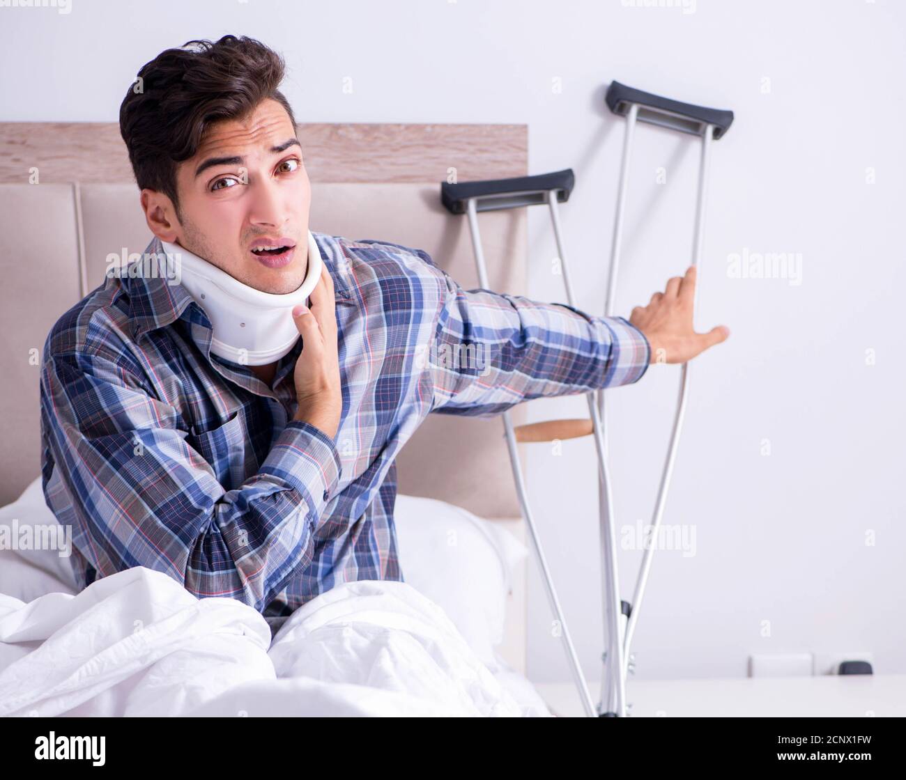 The injured man in bed at home with crutches Stock Photo - Alamy