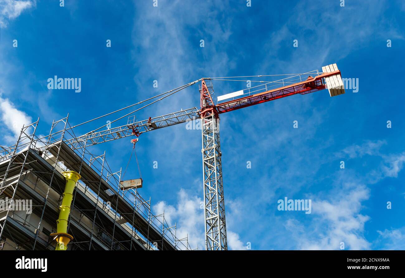 Red tower crane building against a blue sky with clouds. Building crane ...