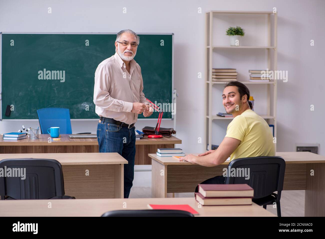 Old teacher and young student in the classroom Stock Photo - Alamy