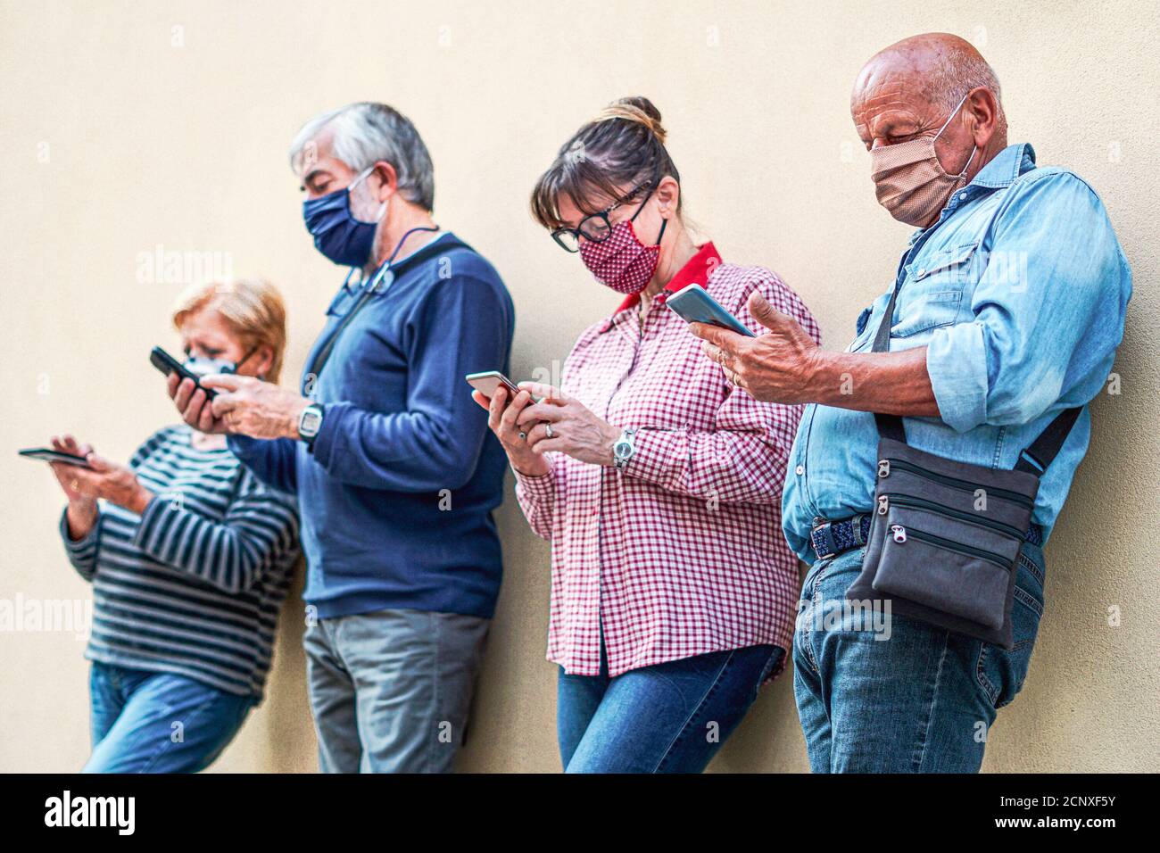 Senior people using smartphones with face mask on - Old man in focus ...