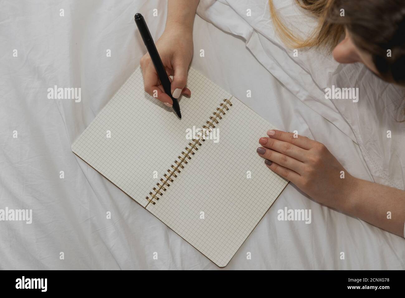Top view of hands and woman part with new manicure writing in a ...