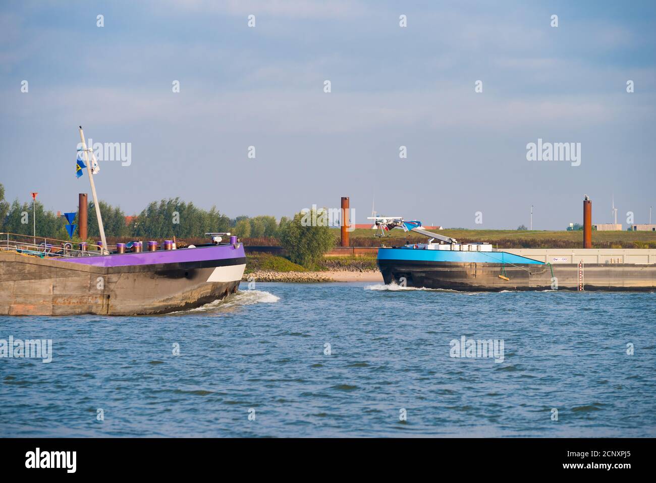 two cargo boats passing each other on the Waal river in the netherlands ...