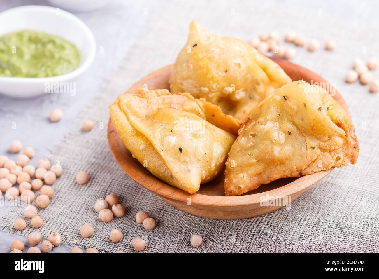 traditional indian food samosa in wooden plate with mint chutney on a ...
