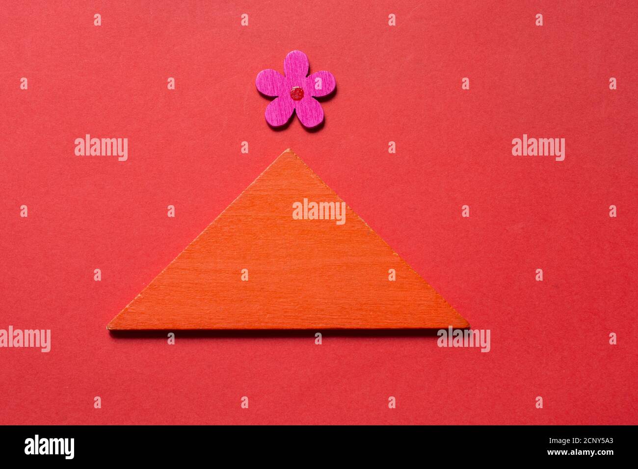 Wooden triangle with a flower on top Stock Photo - Alamy