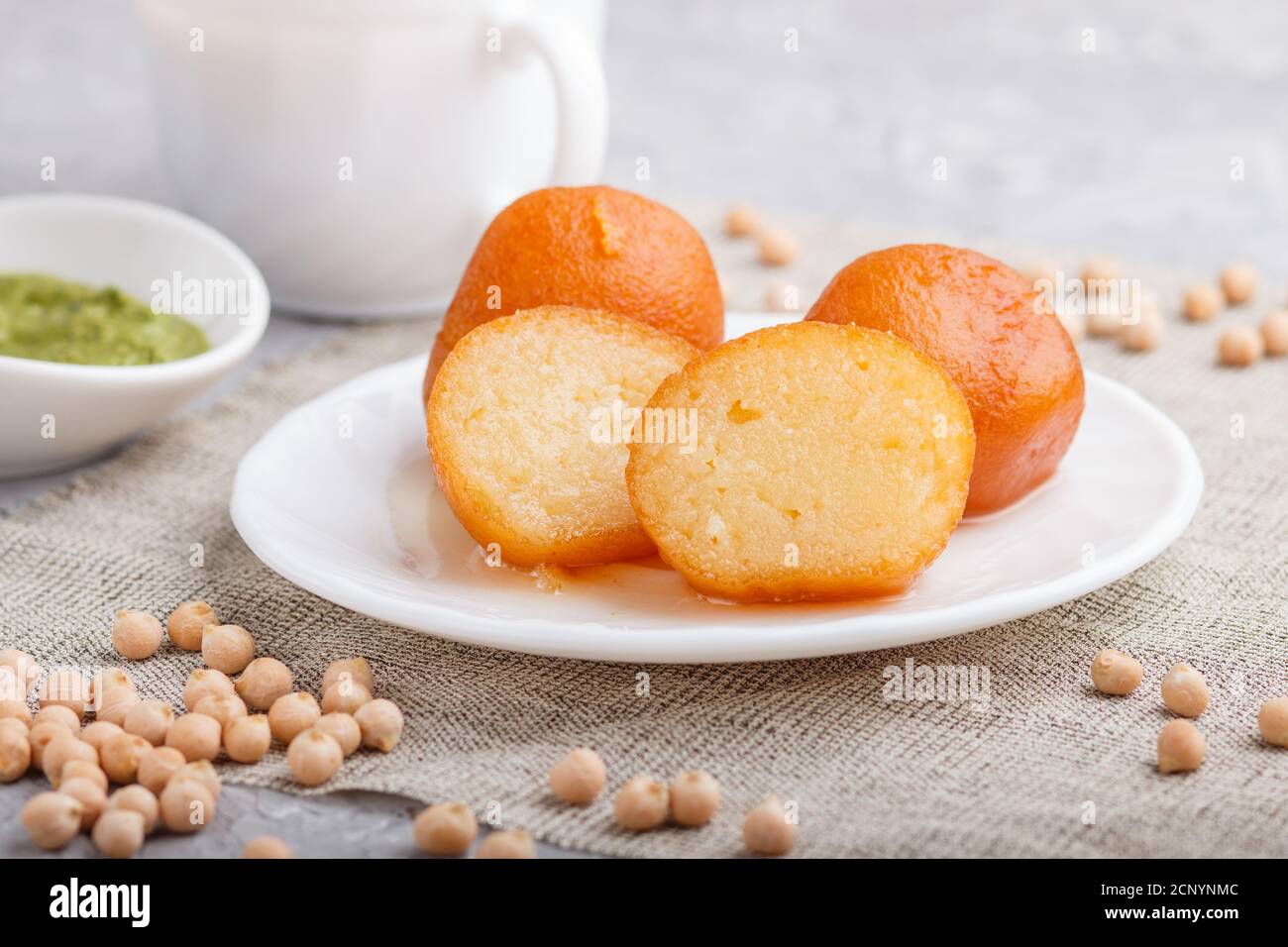 traditional indian candy gulab jamun in white plate with mint chutney ...