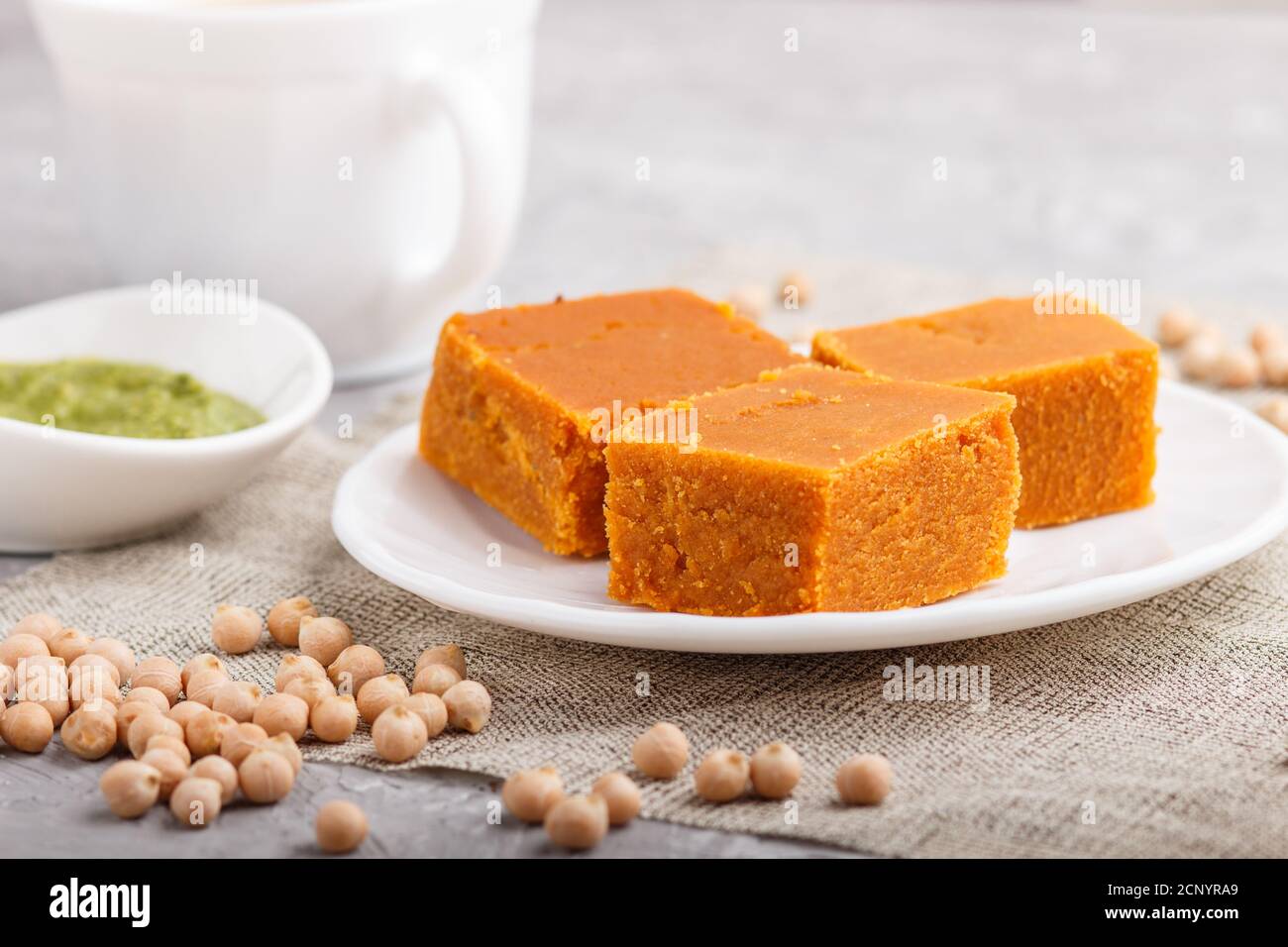 traditional indian candy burfi in white plate with mint chutney on a ...
