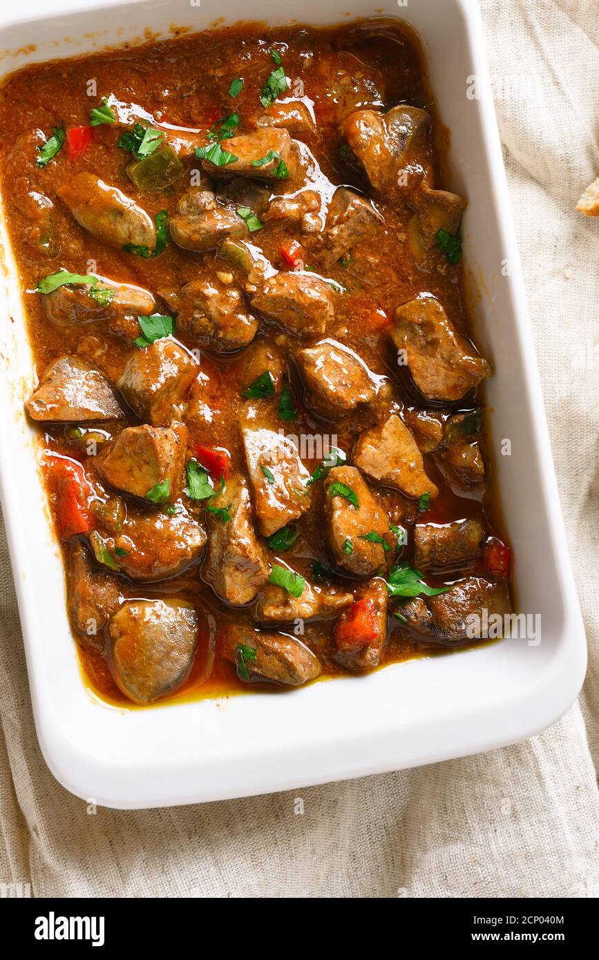 Close up of peri-peri chicken livers in baking dish over light ...