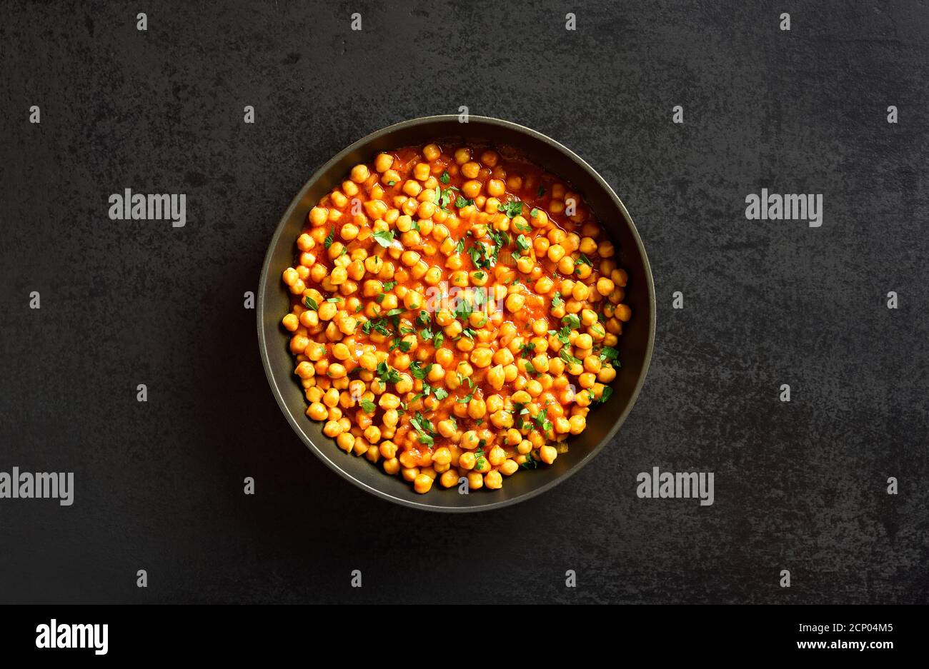 Crispy roasted chickpeas. Indian style dish over black stone background ...