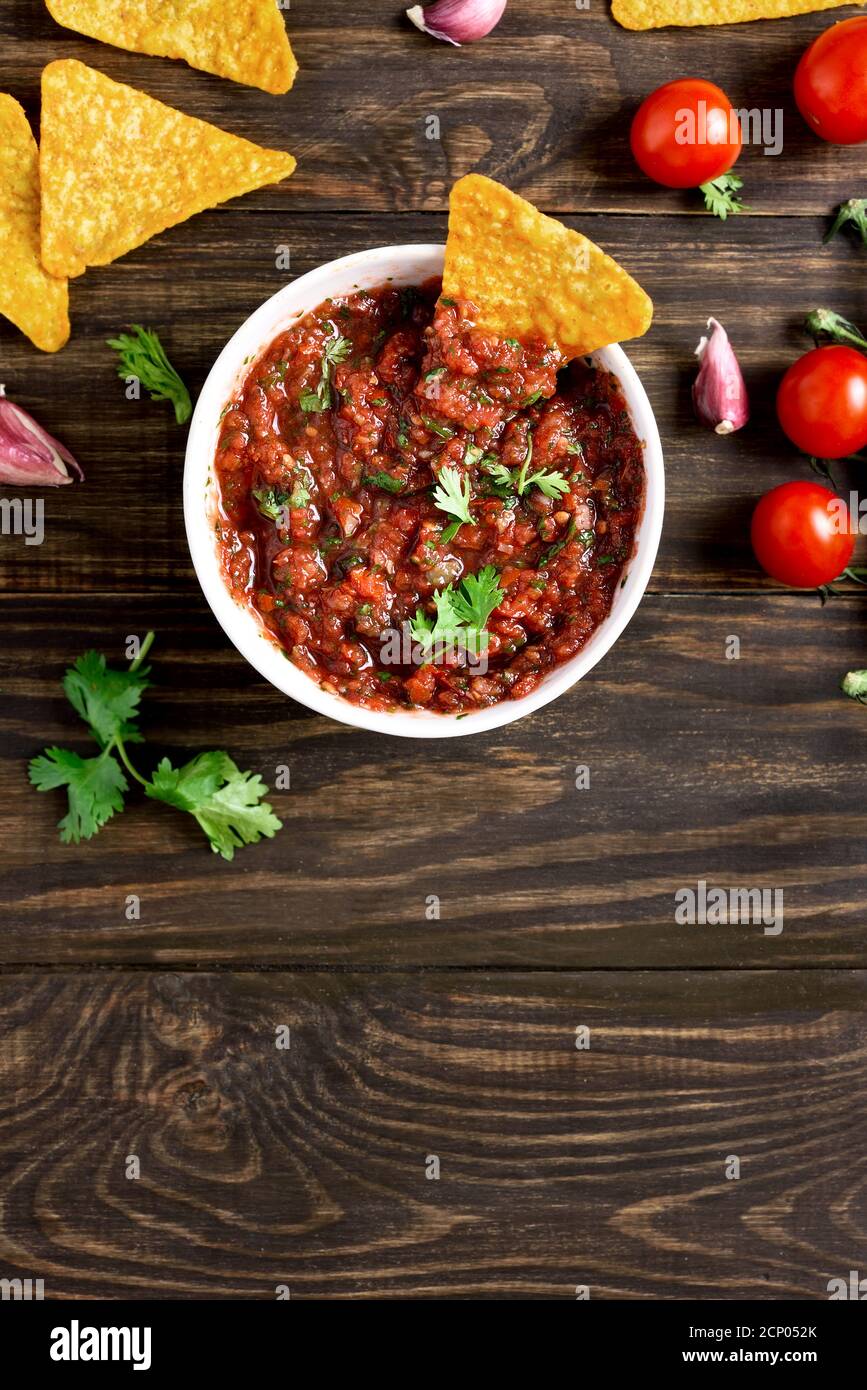 Homemade tomato salsa in bowl over wooden background with free text ...